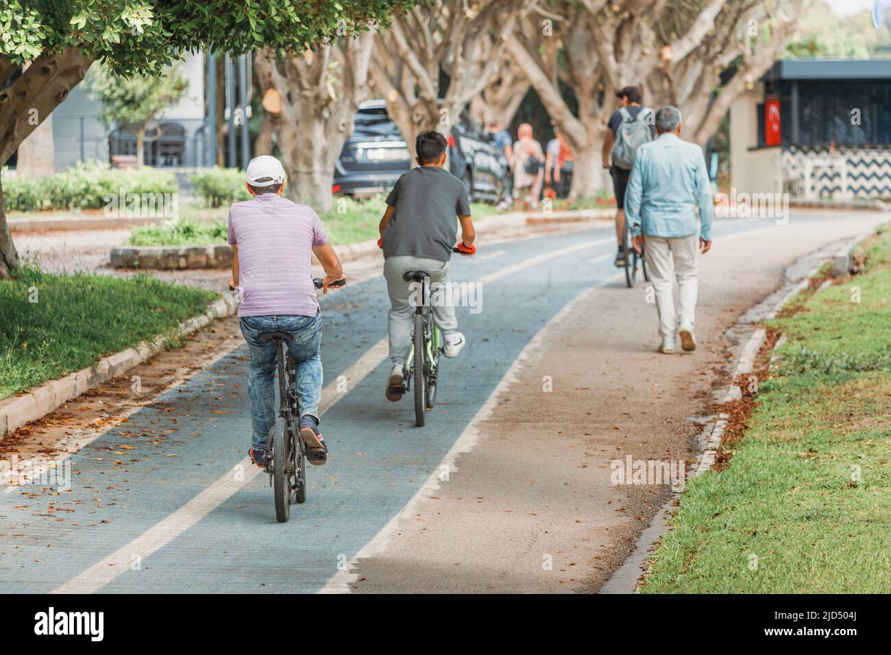 19 May 2022, Antalya, Turkey: Cyclists ride along a bike path in a park ...