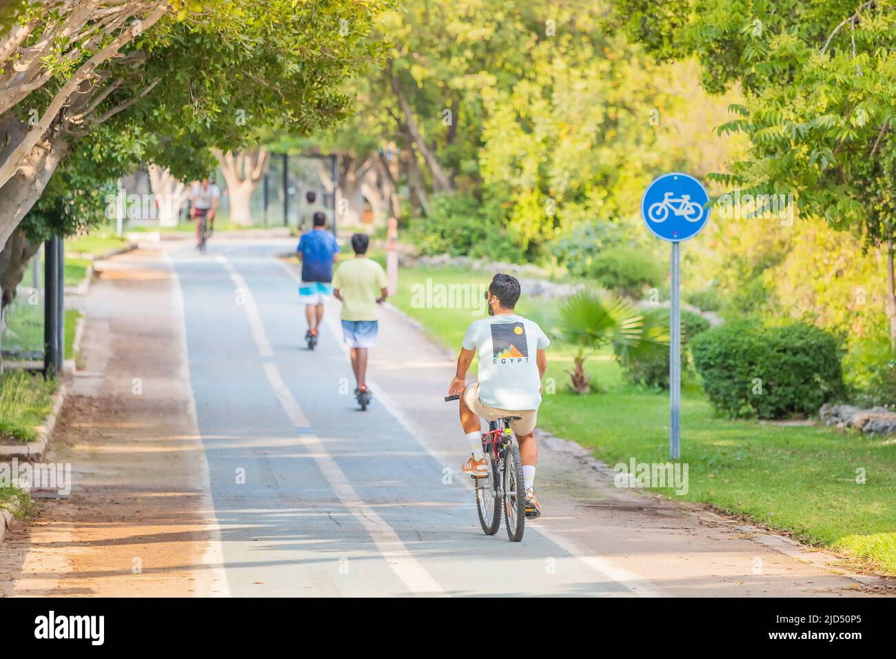 19 May 2022, Antalya, Turkey: Cyclists ride along a bike path in a park ...