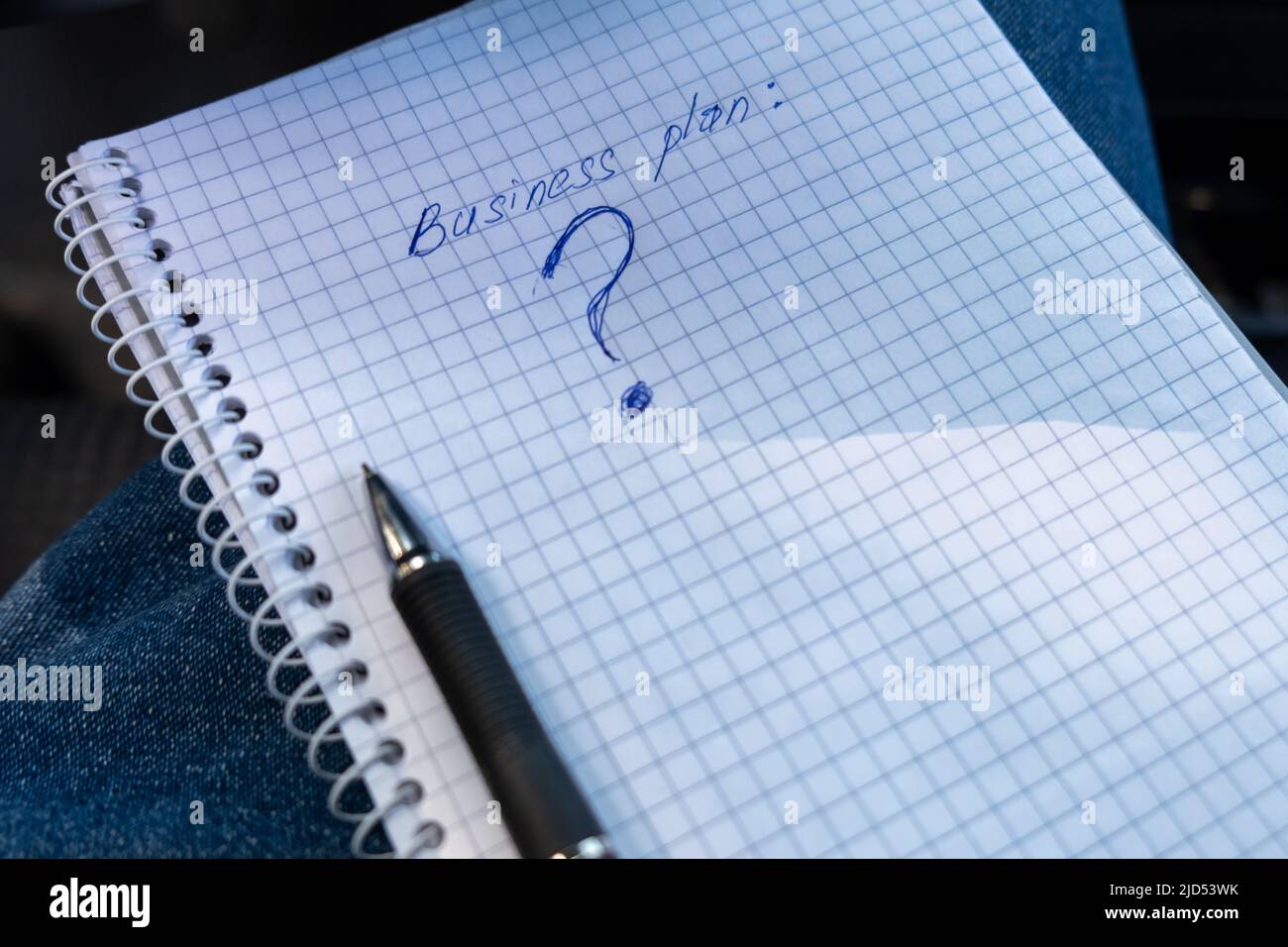 Business plan and question mark written on a notebook. Reflections on ...