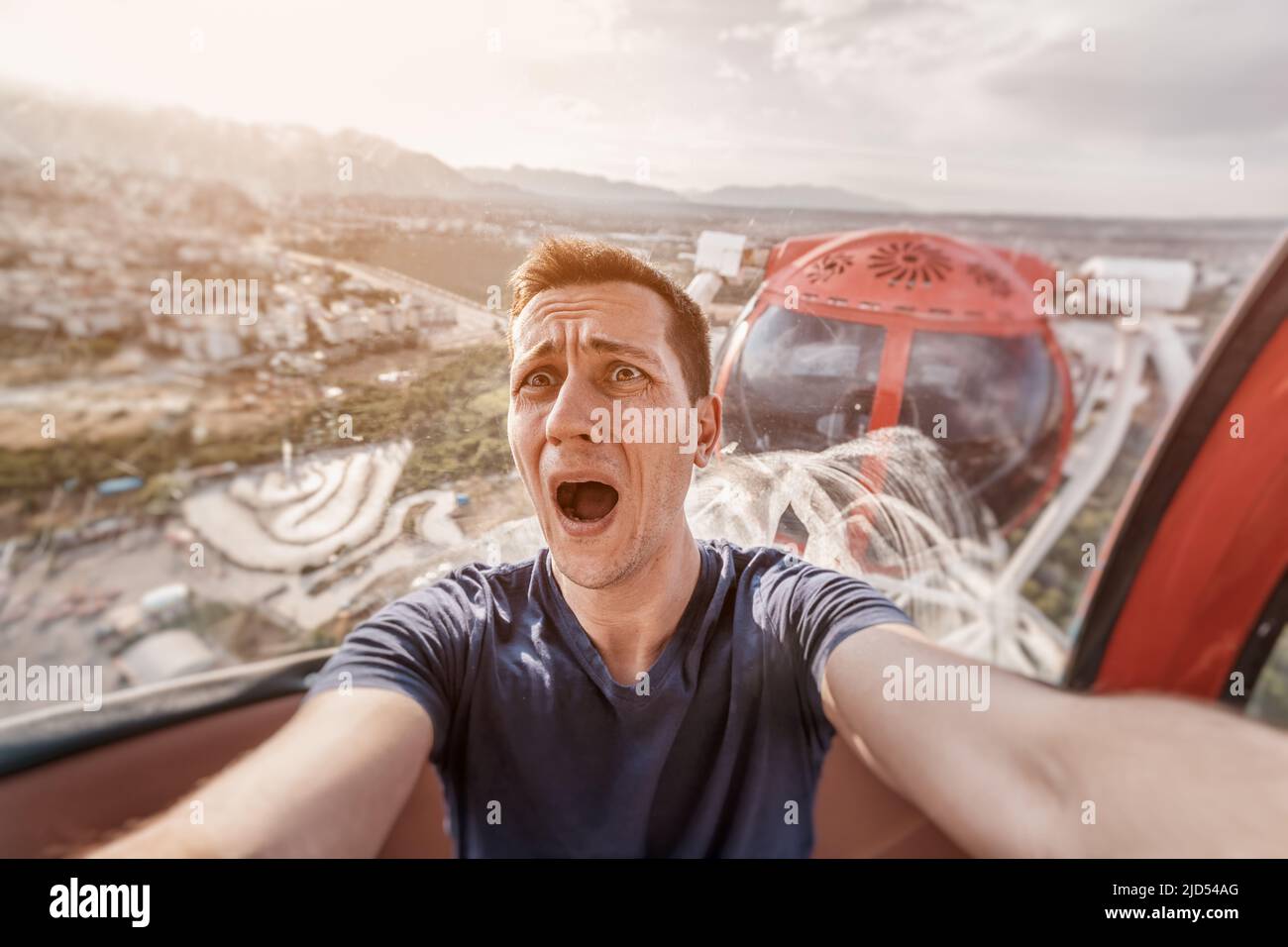 A guy with acrophobia or fear of heights screams with funny emotions on ...