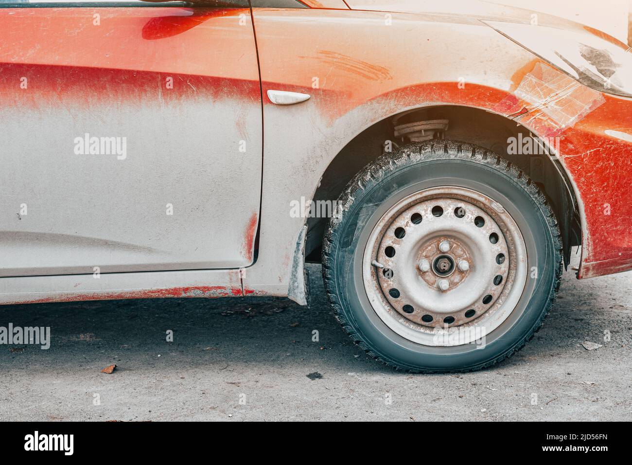 An unwashed and soiled battered car in the spring. The concept of road ...