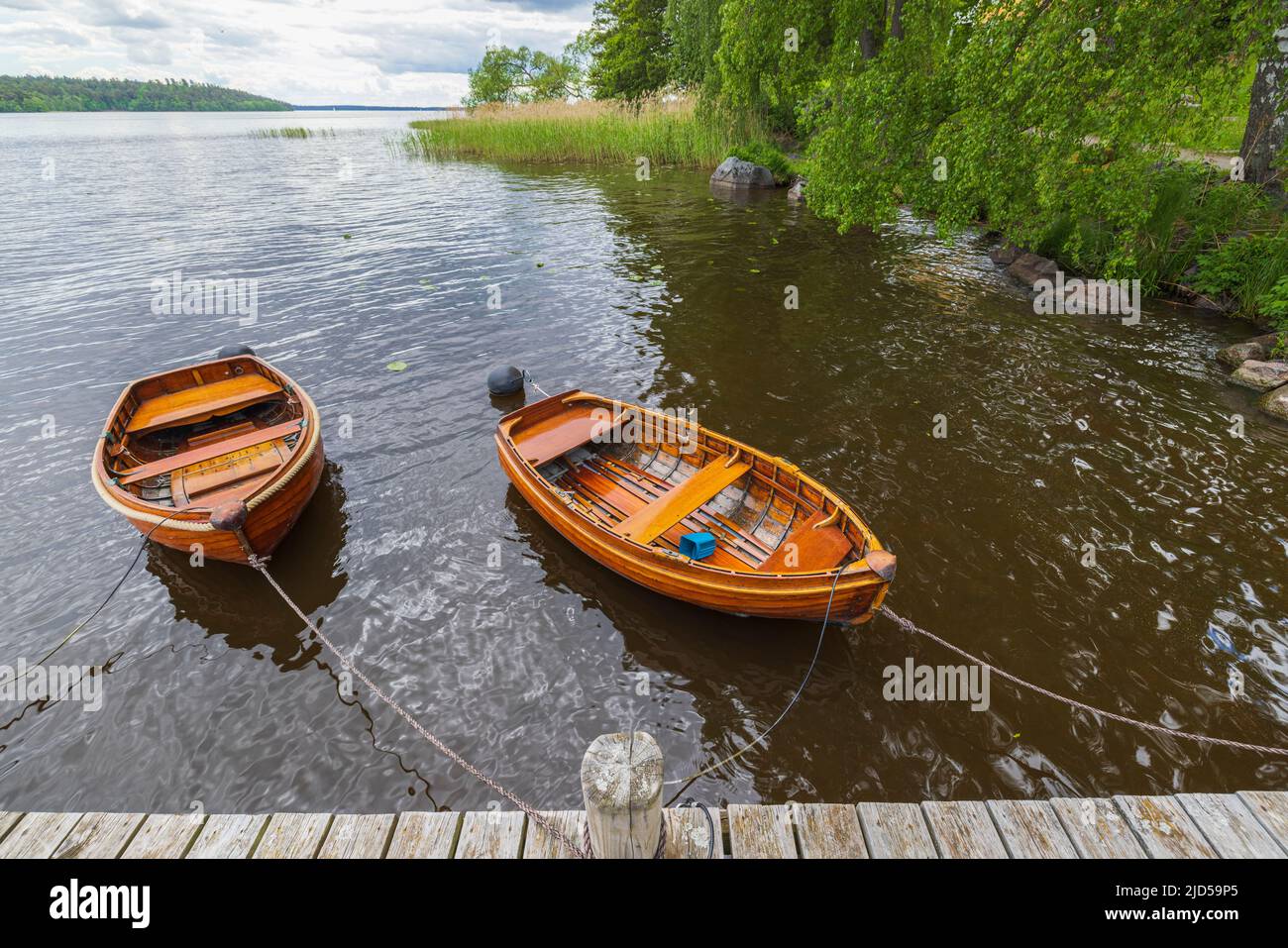 Beautiful view of lake with two boats parked in shore on water ...