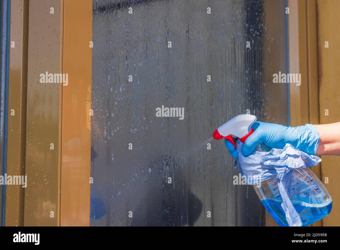 Close up view of person's hand, cleaning window in house using window ...