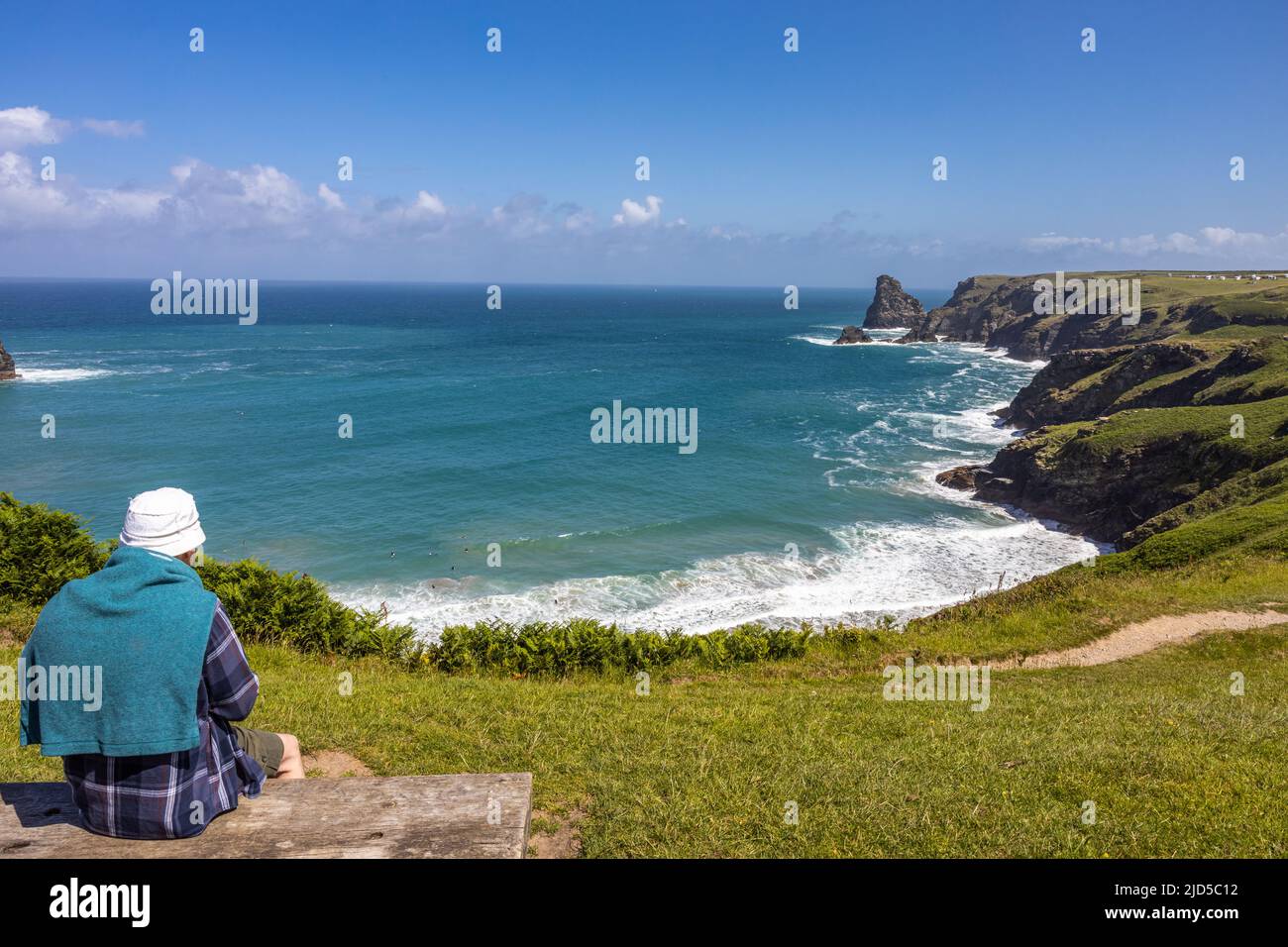 A man sitting on a bench admiring the spectacular coastal view close to ...