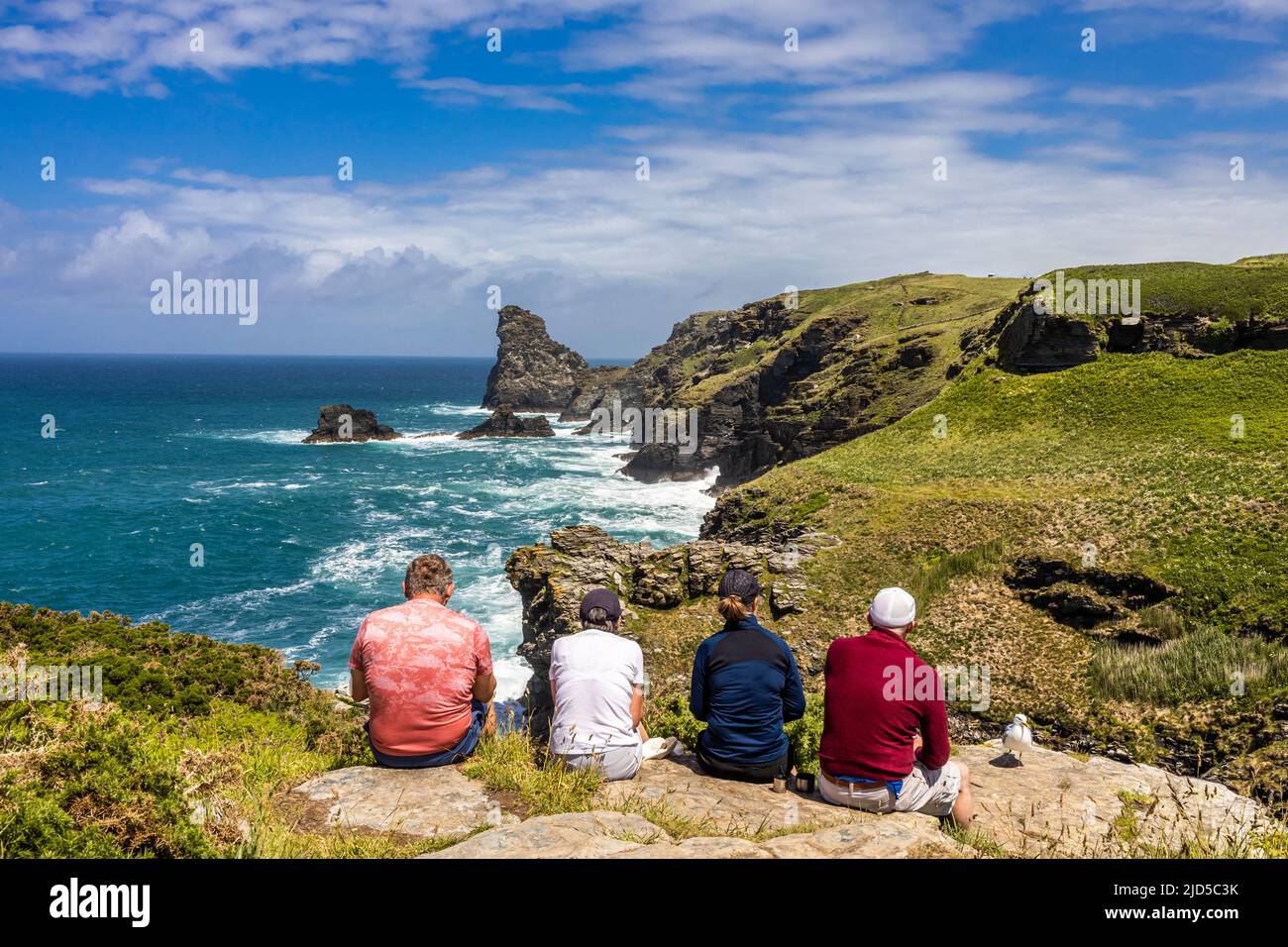 Two couples enjoying a hiking rest stop and the magnificent sea view ...
