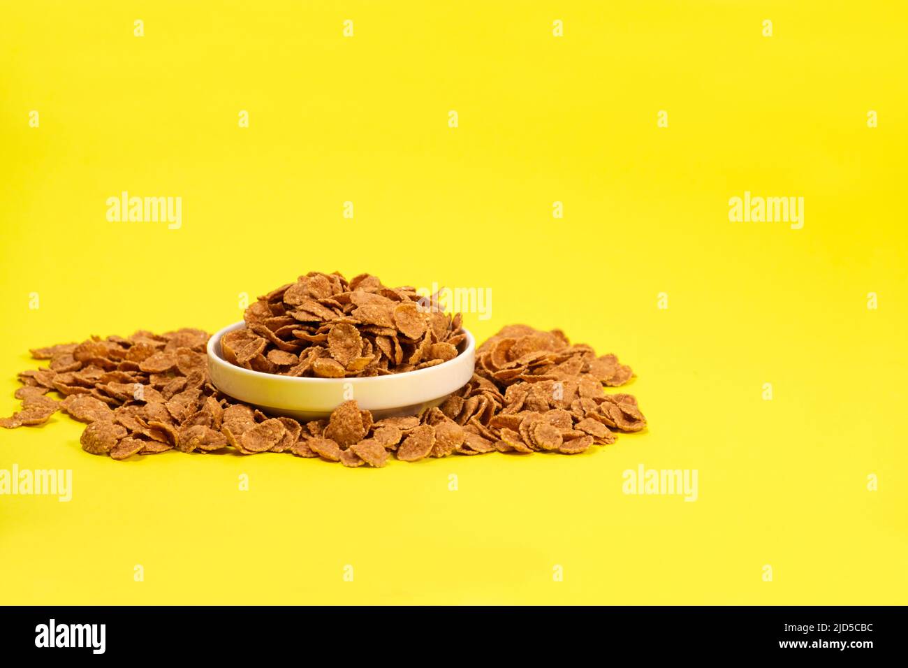 Durum wheat flakes - quick breakfast cereal on a plate on a yellow ...