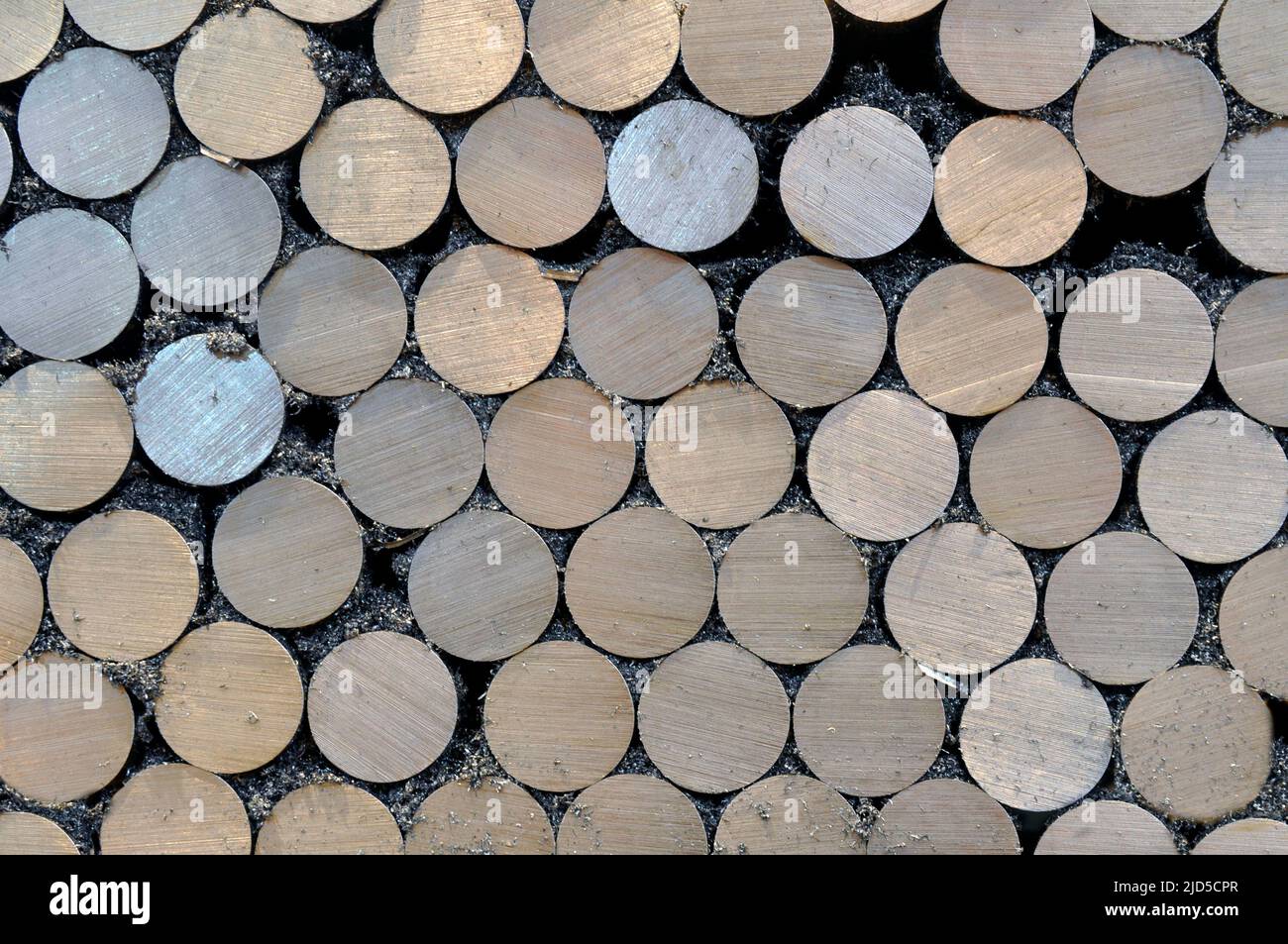A bunch of thick steel rods sawn on a band saw in a factory. Background ...