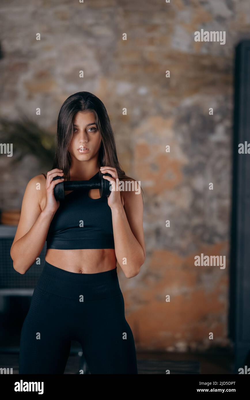 Young woman posing at the camera with dumbbells in her hands Stock ...