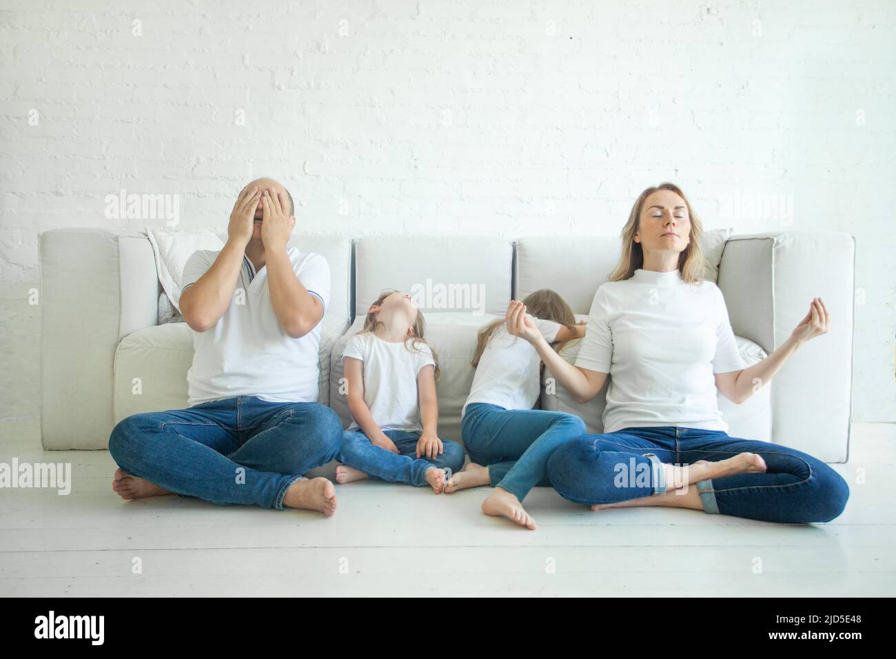 Calm mother with closed eyes meditating in lotus pose on floor ...