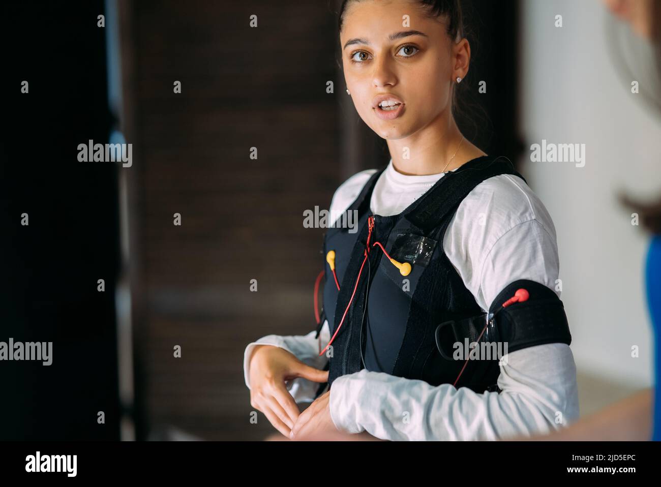 EMS training. Girl doing exercises in a suit with cables Stock Photo ...