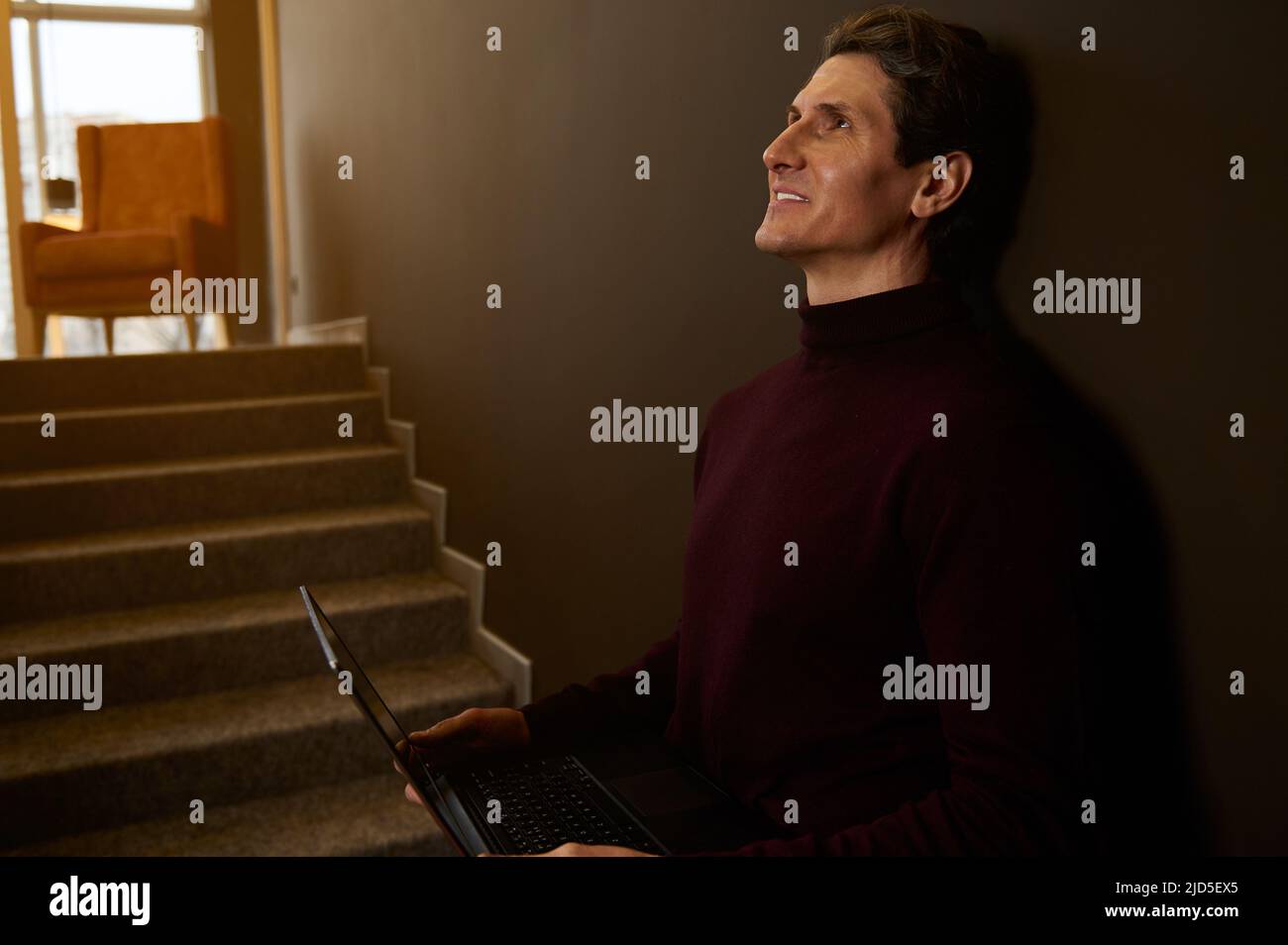 Side portrait of a handsome Caucasian man working remotely on laptop ...