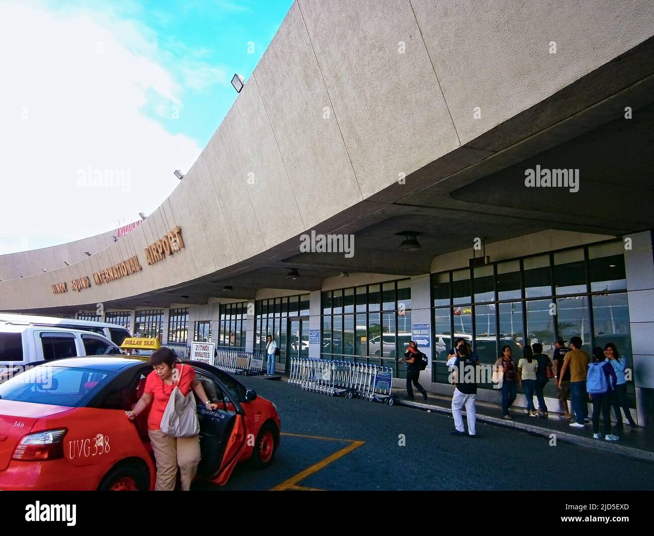 People and taxis waiting outside the terminal building at Ninoy Aquino ...
