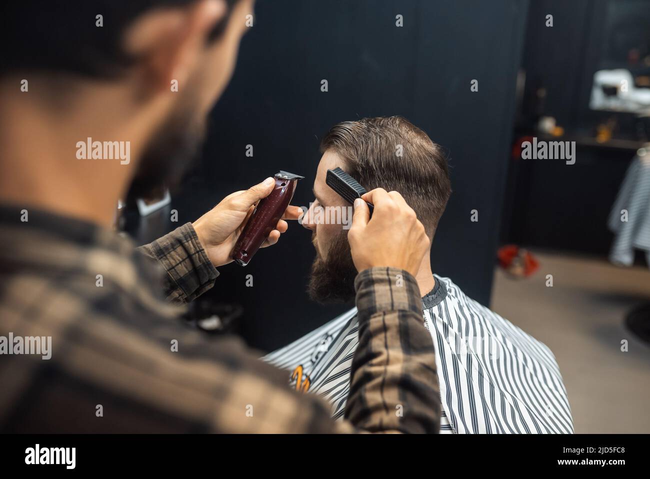 Master in barbershop makes men's haircutting with hair clipper Stock ...