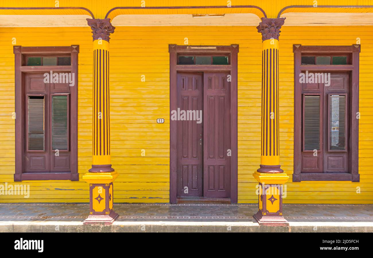 Beautiful yellow house with columns, and with brown door and windows in ...