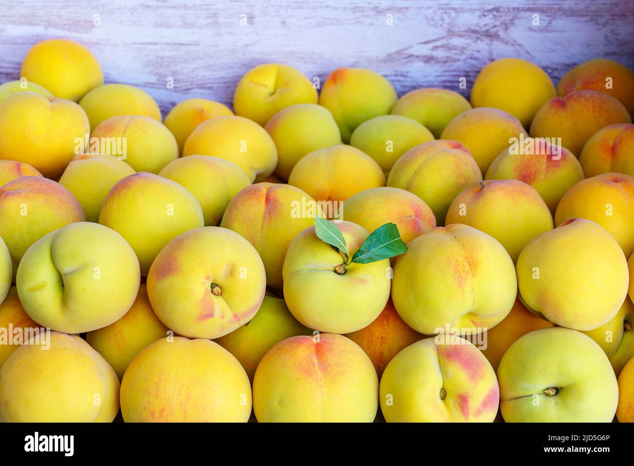 Many yellow peaches with appetizing appearance placed in a container ...