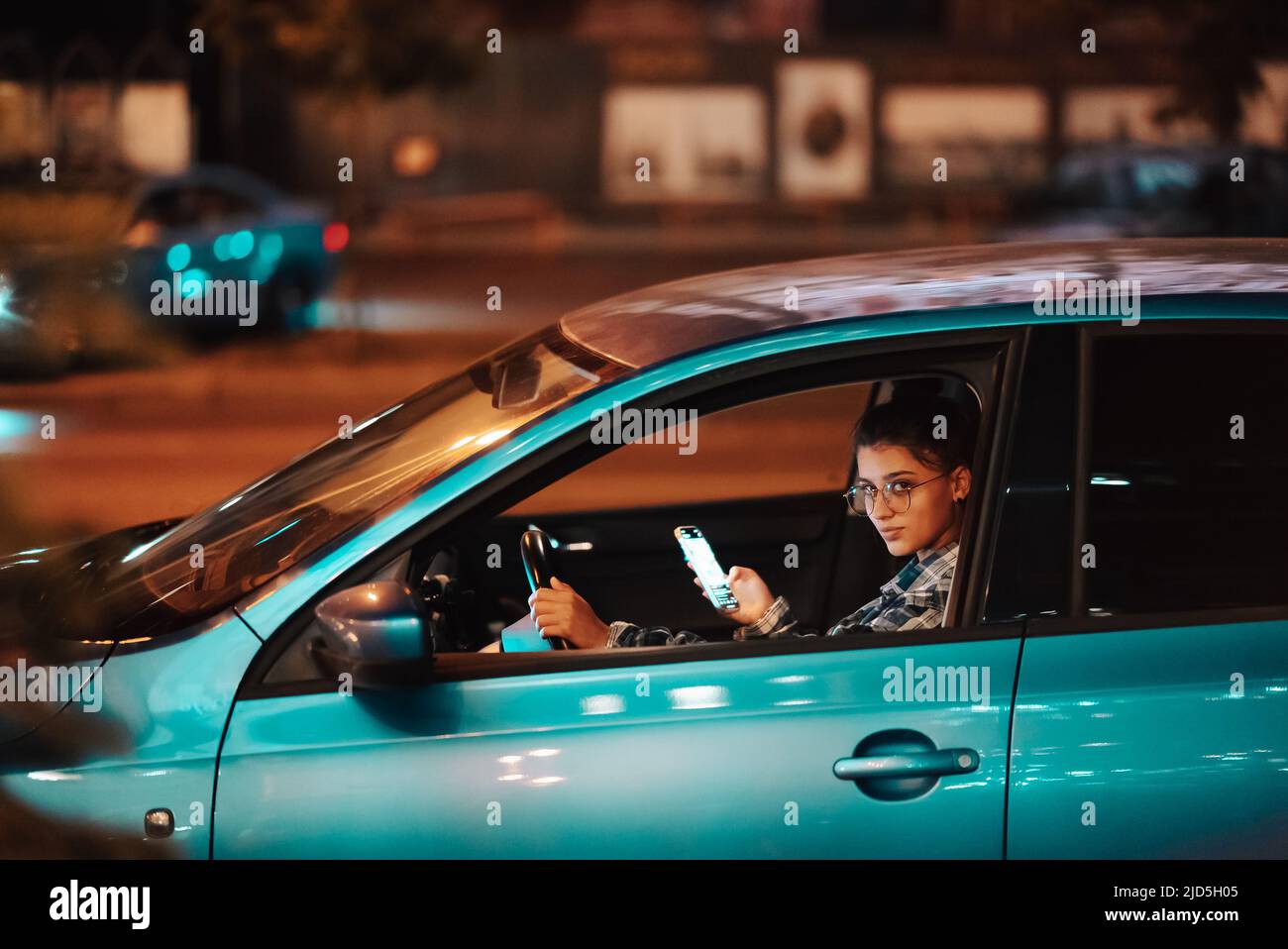 Lost female driver using mobile phone while driving at night Stock ...