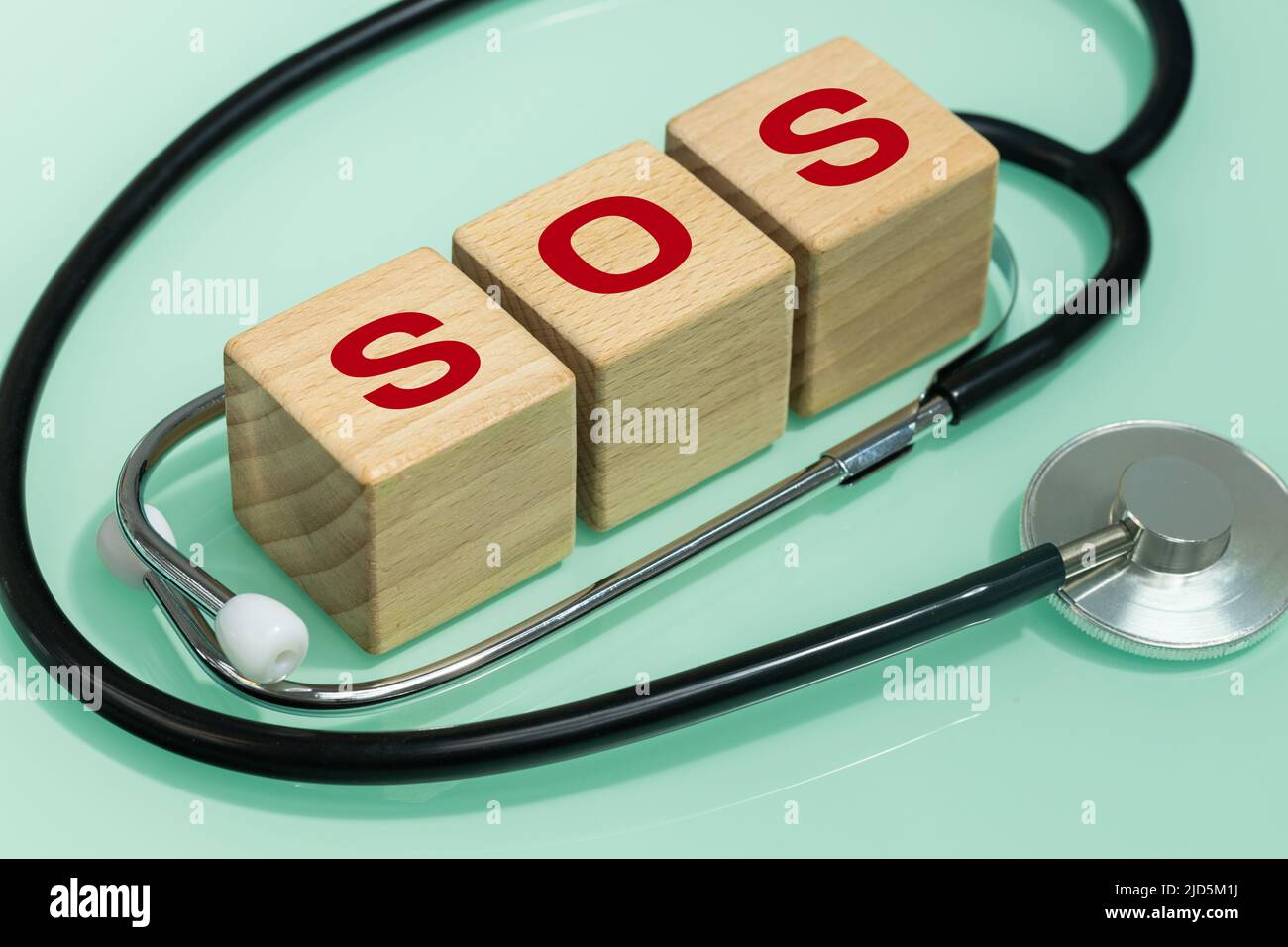 Red SOS inscription on wooden blocks and medical stethoscope, Health ...