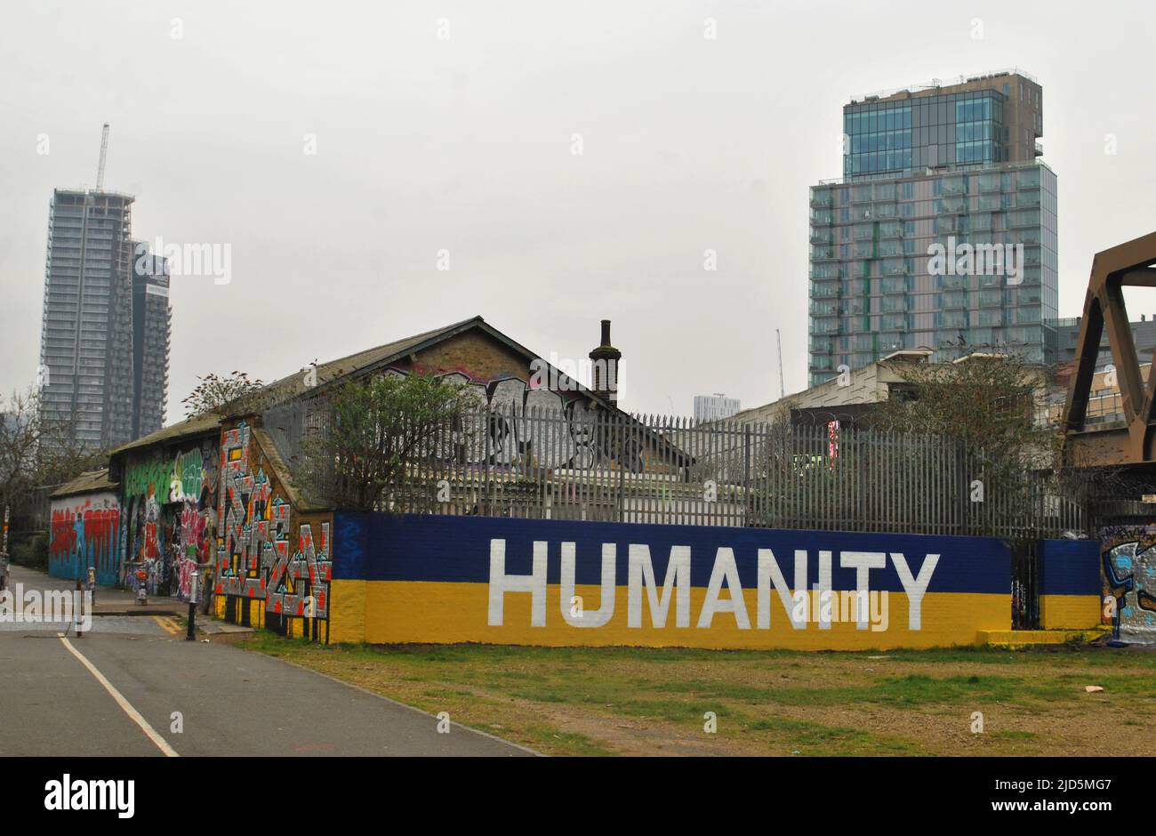 THE WORD HUMANITY ON A YELLOW & BLUE BACKGROUND, IS WRITTEN ON A WALL ...