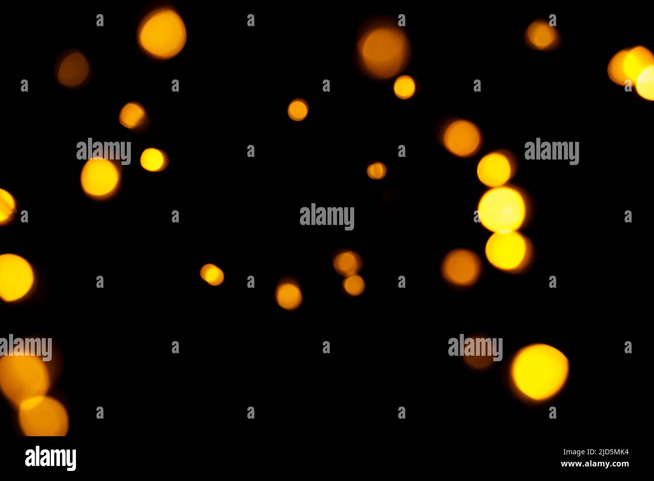 Gold bokeh on dark background. Defocused golden lights. New Year ...