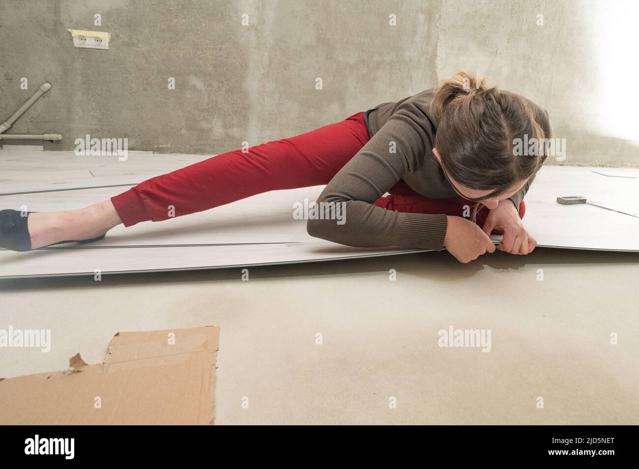 Woman installs quartz vinyl flooring at home, exhausted woman from work ...