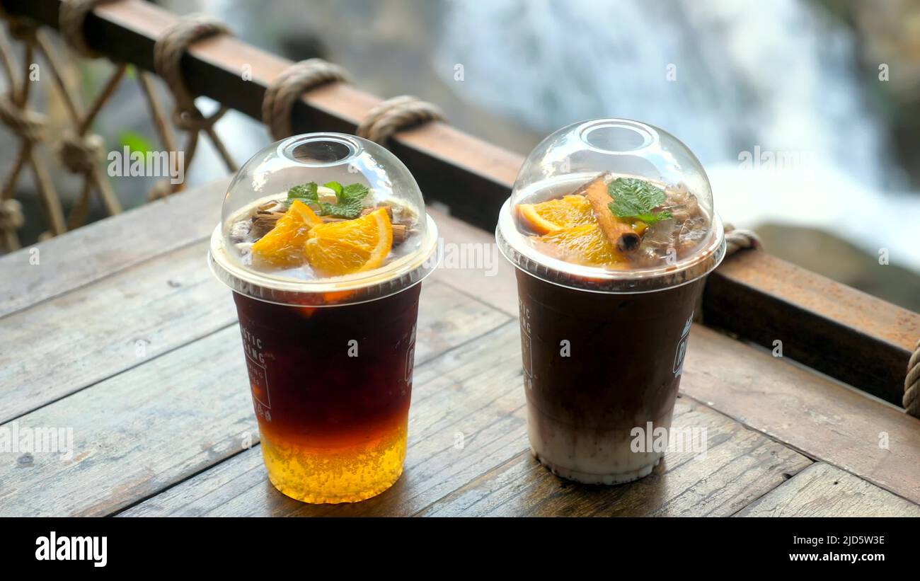 Two cups with healthy drinks in outdoor cafe. Detox cold drinks in ...
