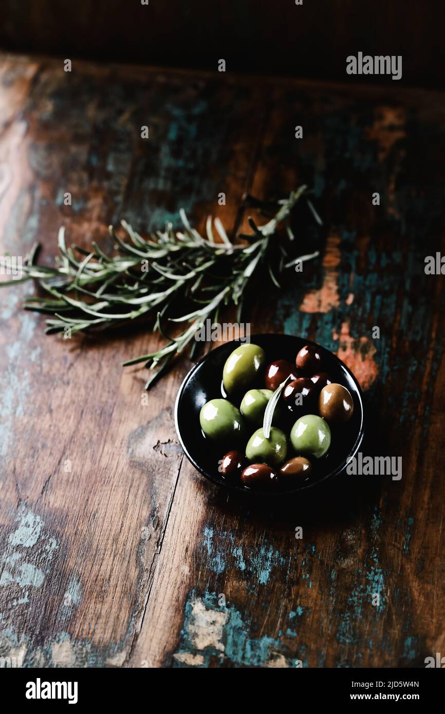 Various olives on rustic wooden background Stock Photo - Alamy