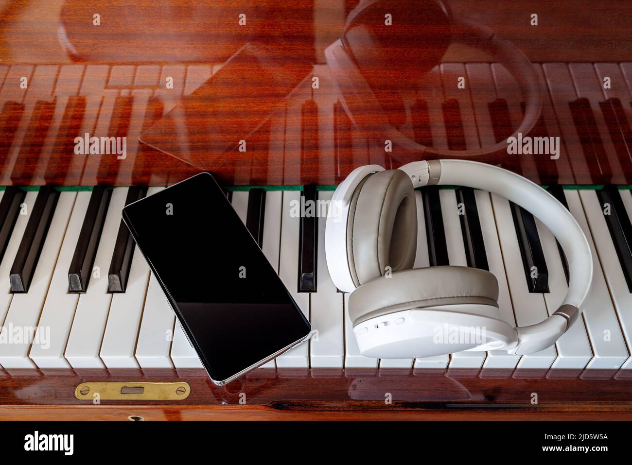Top view, there are headphones and a phone on the piano. Online music ...