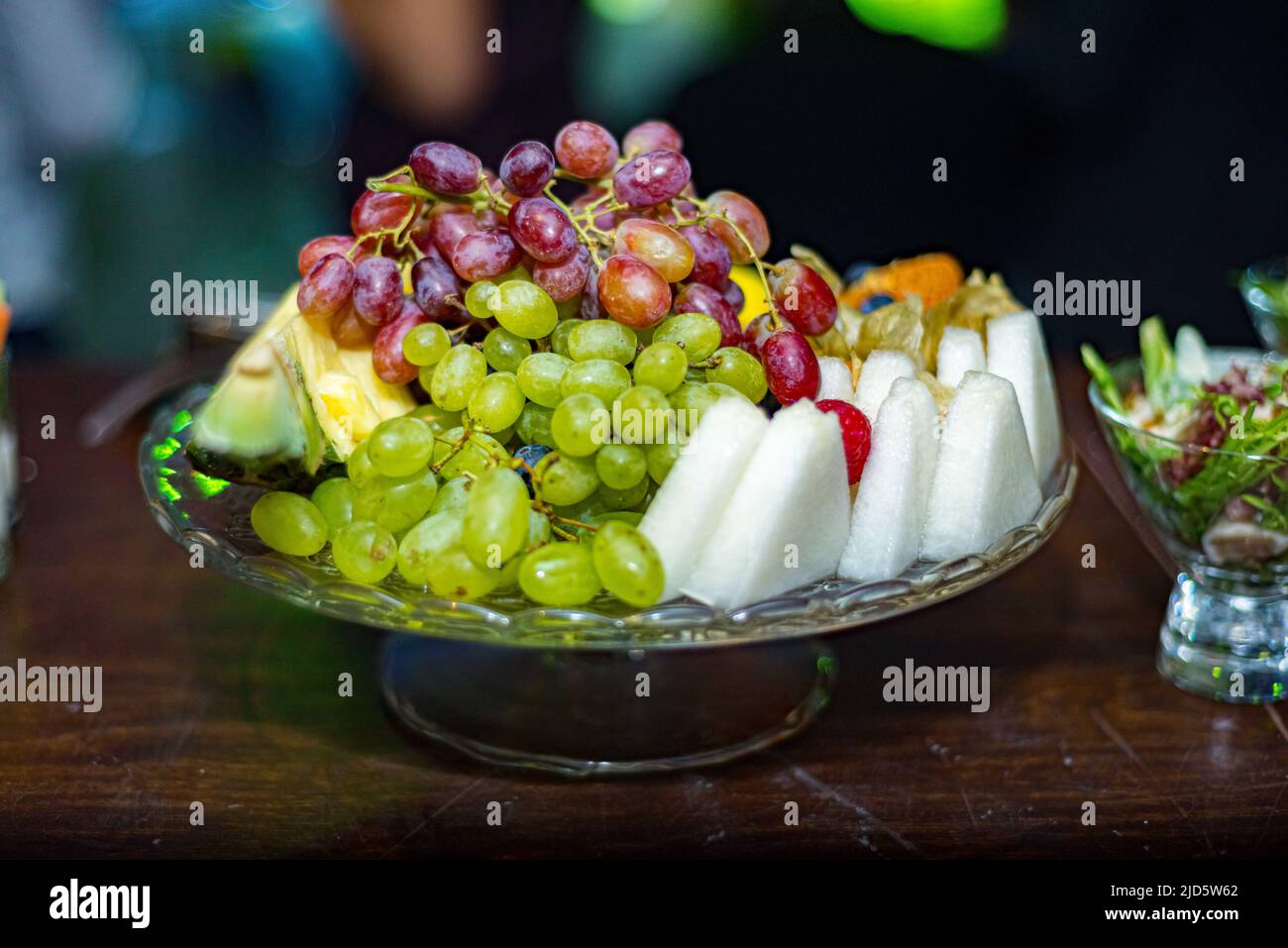 Fruit plate. Stylishly lined fruit: melon slices, grapes. Catering ...