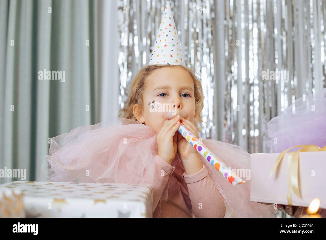Pretty girl in pink carnival outfit , with silver stars on her face and ...