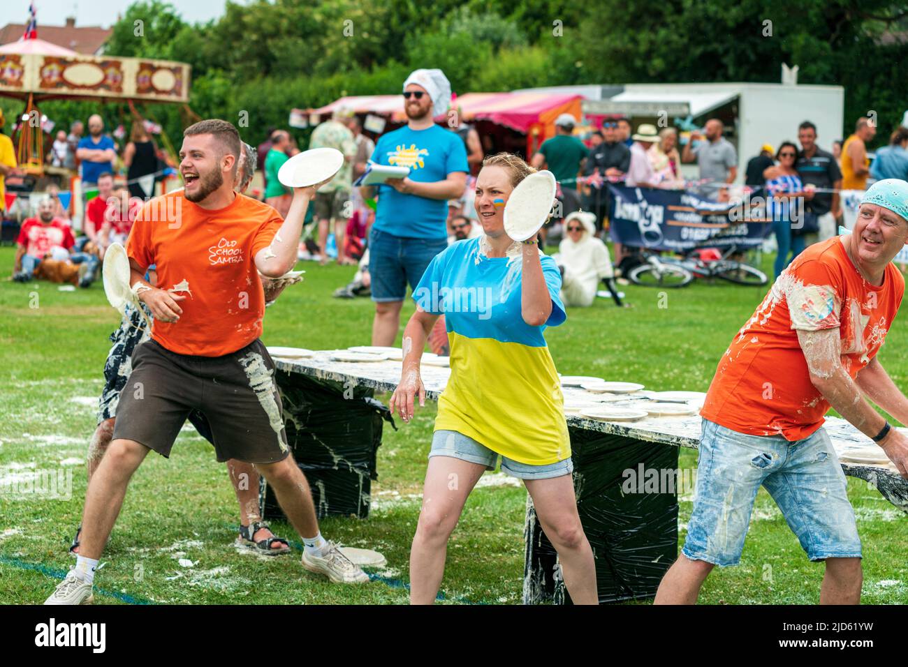 Team of four people throwing custard pies at another, unseen, team at ...