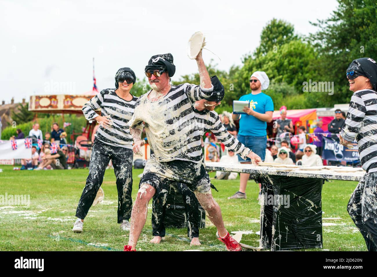 Team of four people in convict costumes throwing custard pies at ...