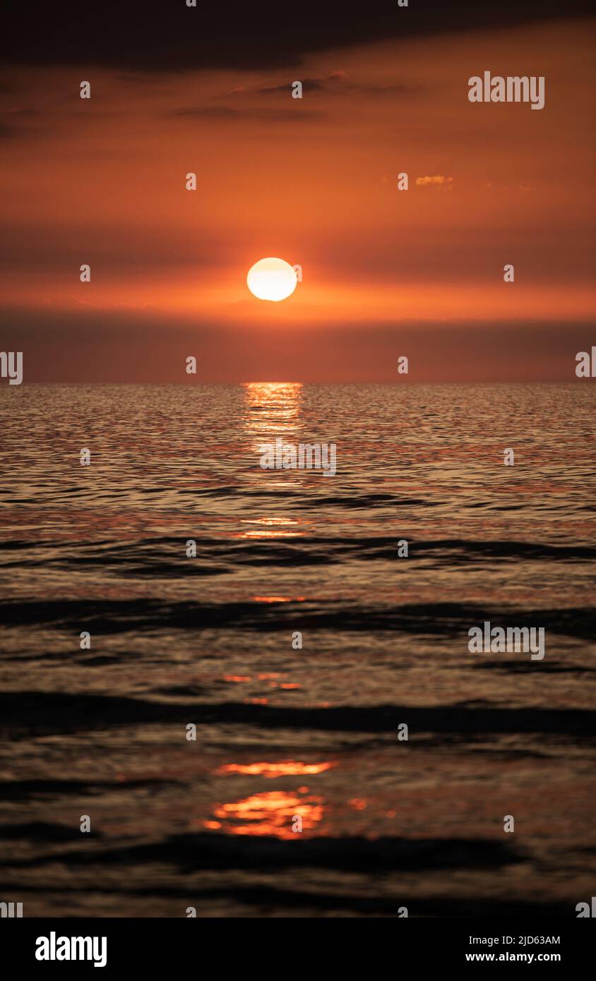 Sun setting over the sea Stock Photo - Alamy
