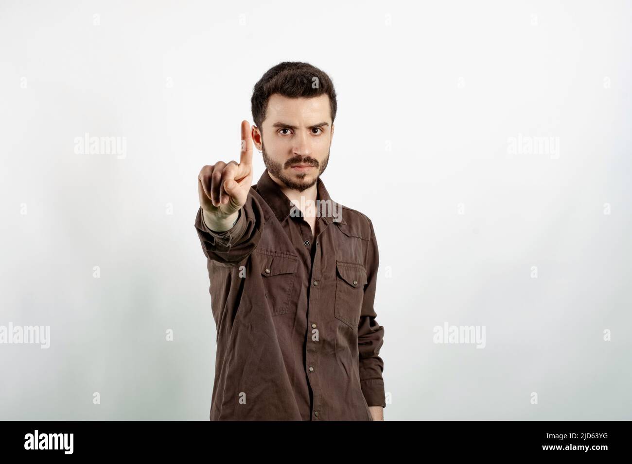 Young man wearing brown shirt posing isolated over white background ...