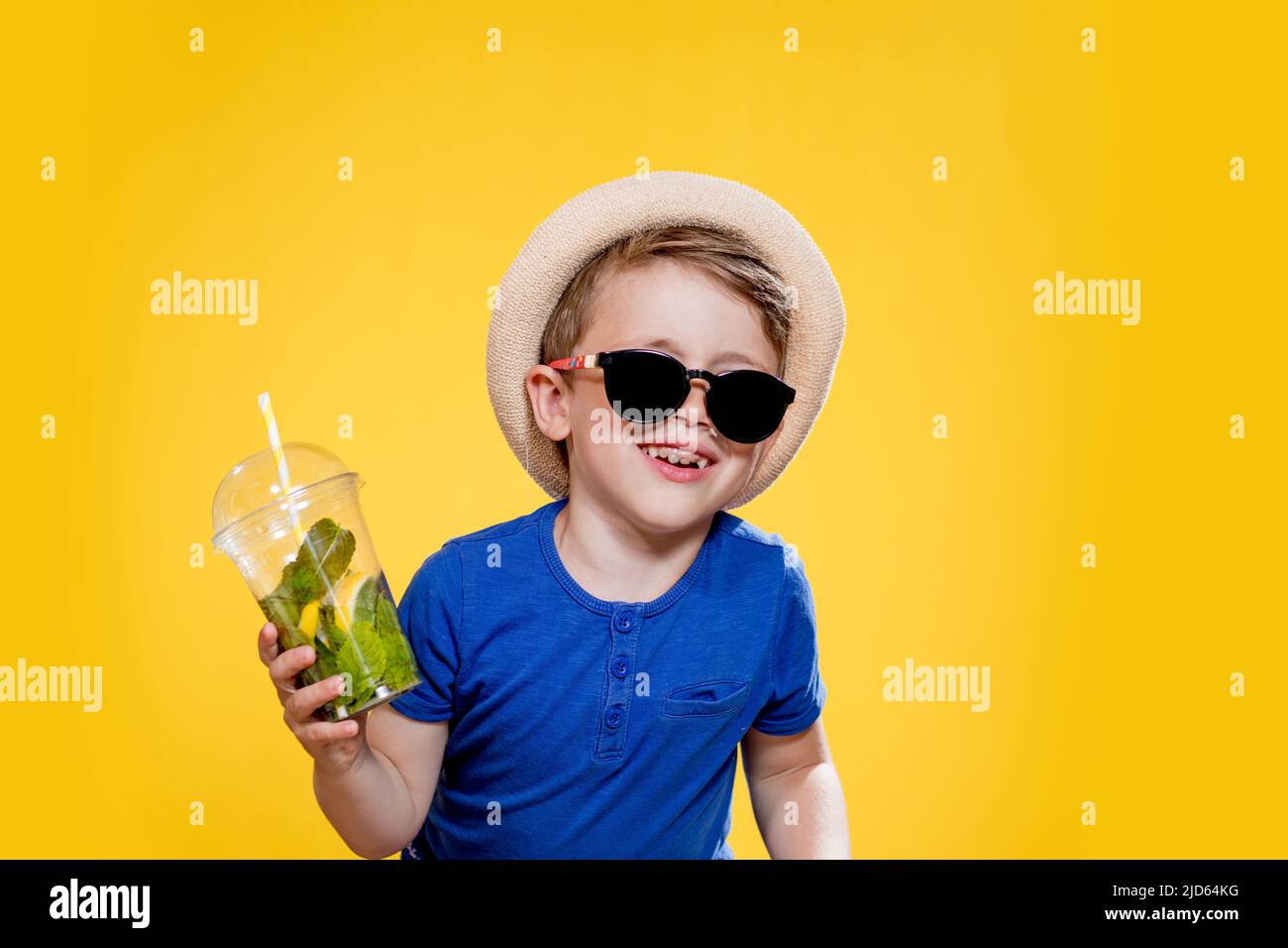 Boy in summer outfit wearing sunglasses and enjoying while drinking a ...