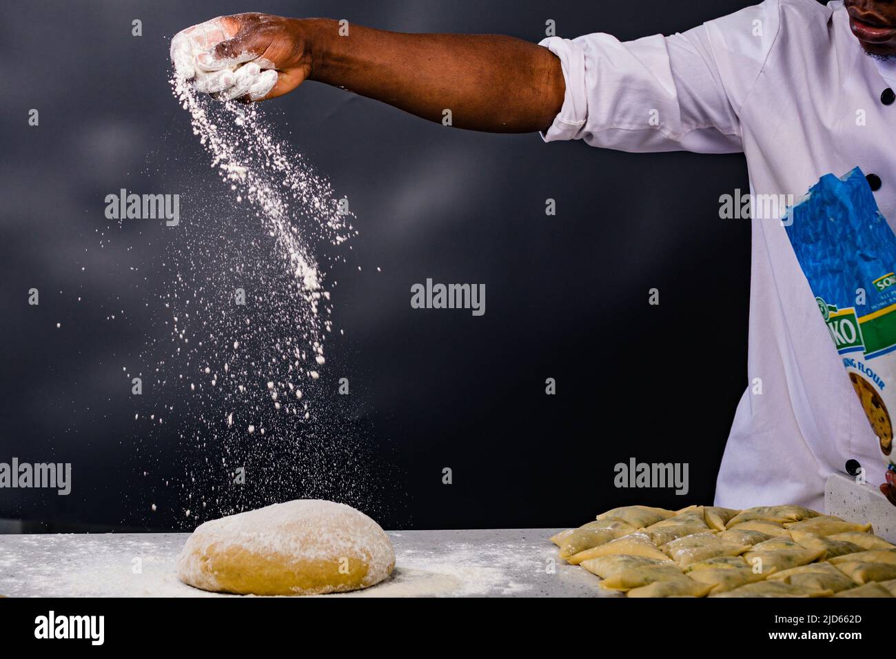 Hands splashing wheat flour kneaded Stock Photo - Alamy