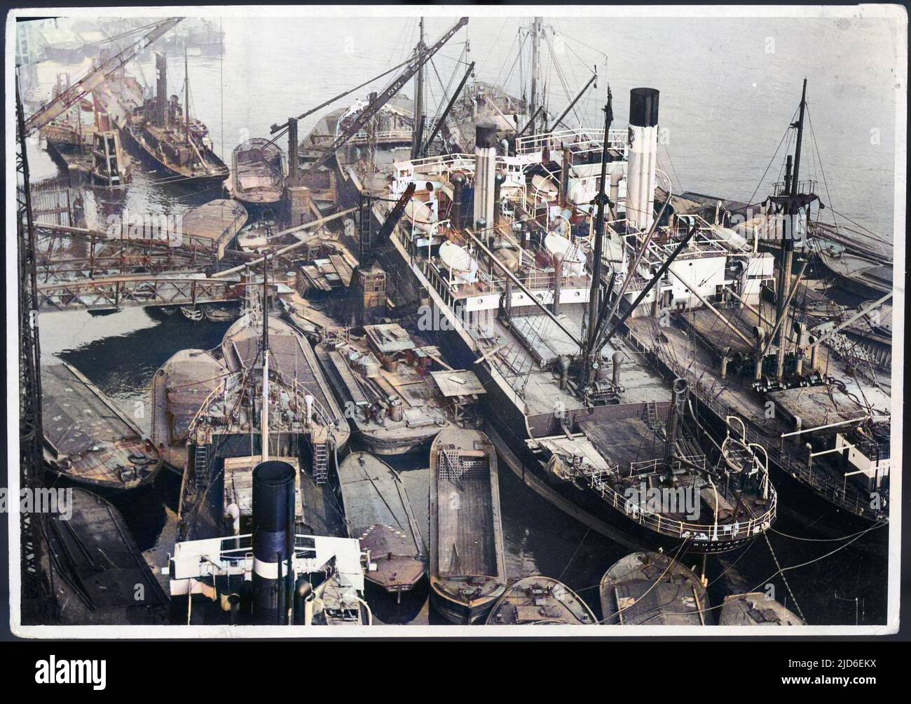Barges, cranes and tramp steamers at the London Docks. Colourised ...