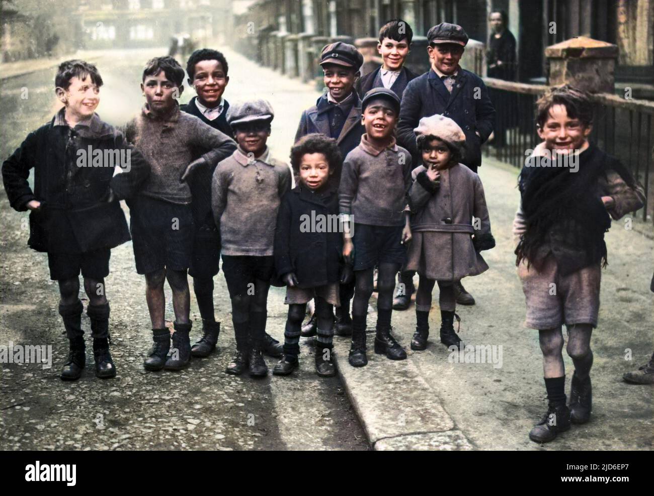 A group of working class children, black and white, playing together on ...