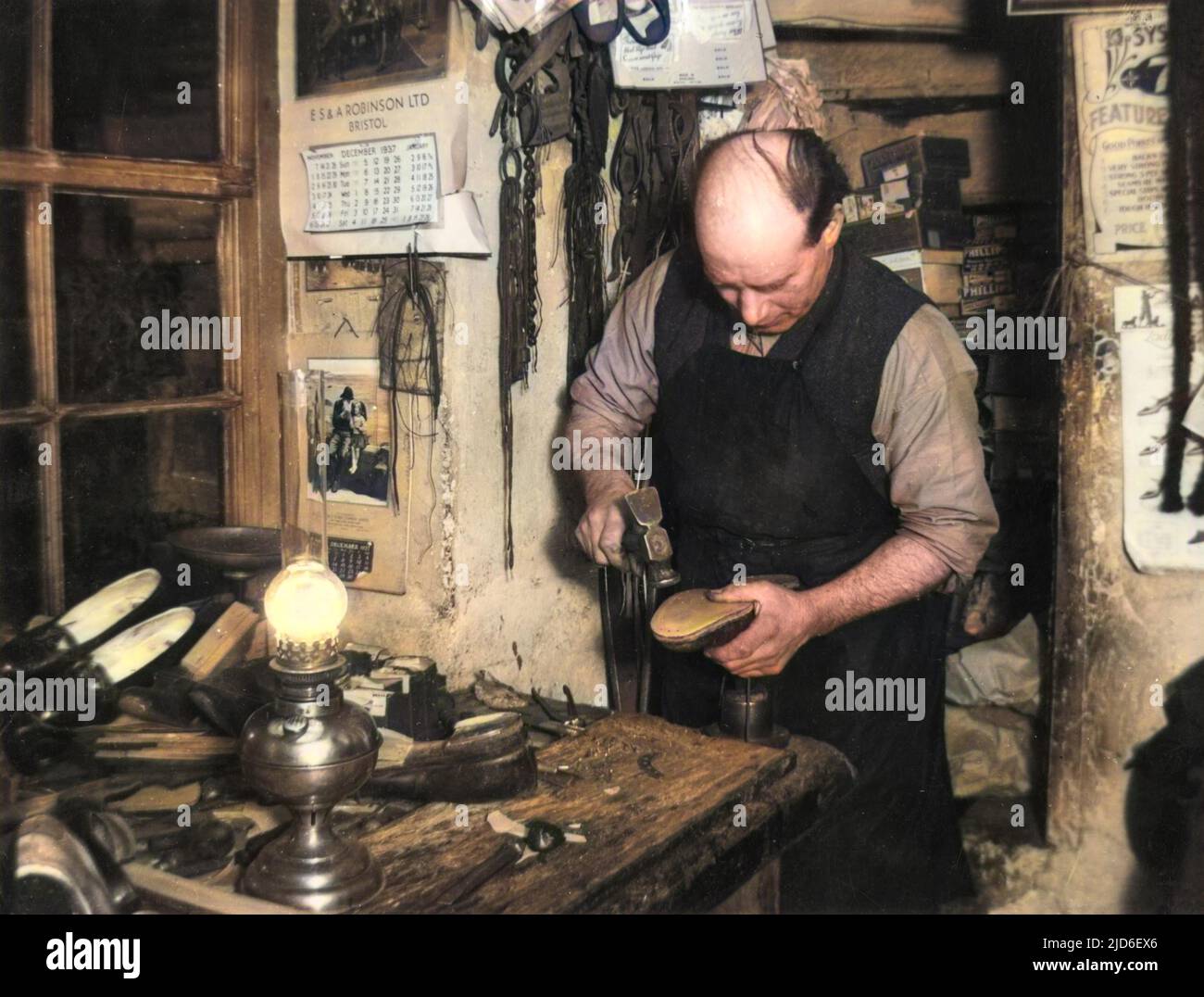 The village cobbler working by the light of his oil lamp in his ...