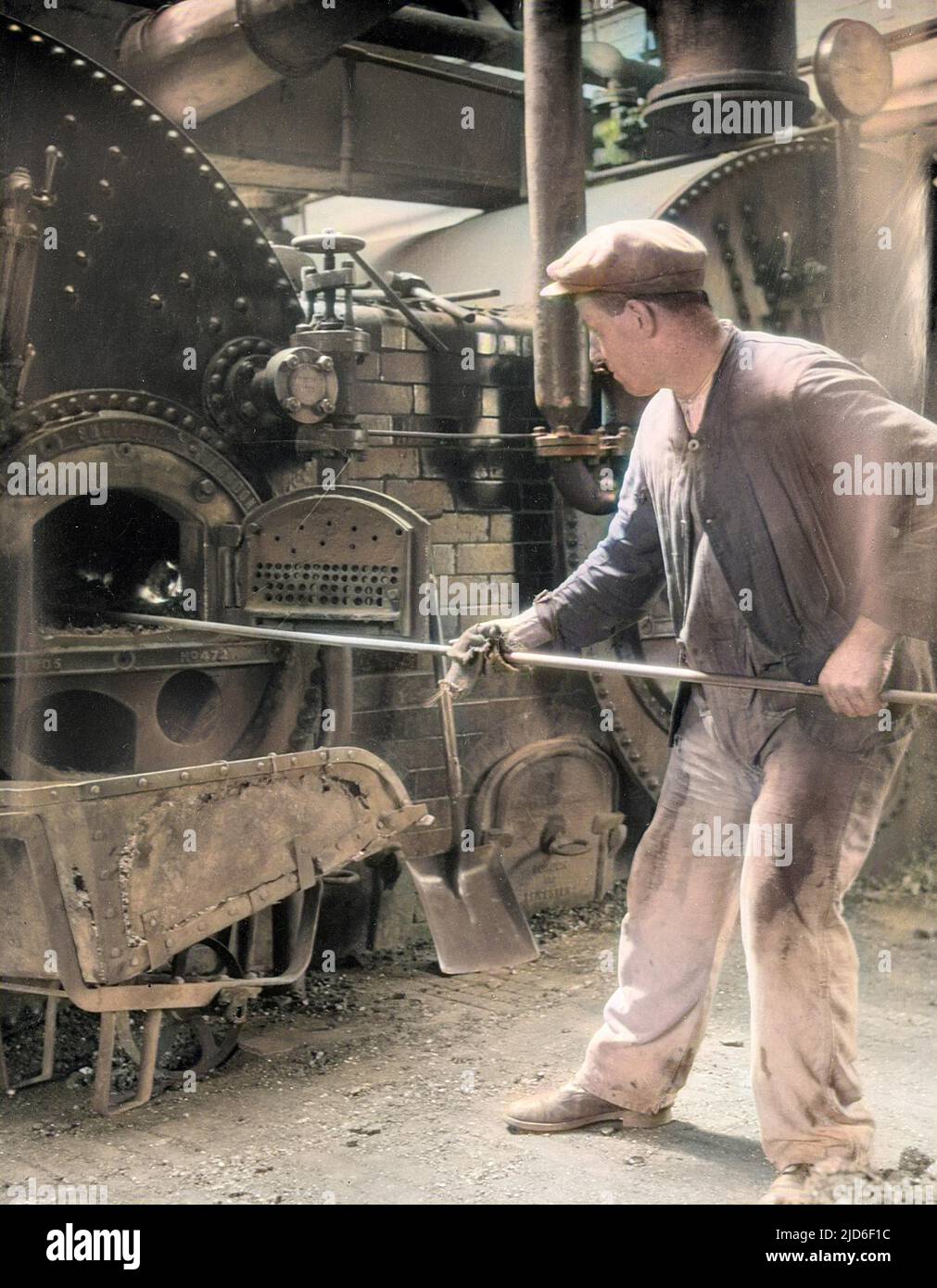 A stoker uses a long stick to stoke up the fire in a factory ...