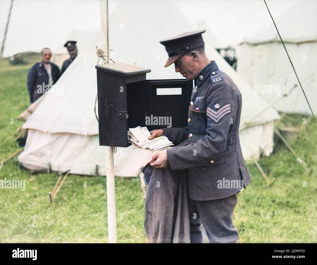 A military postman for the British army collecting post from a mail box ...
