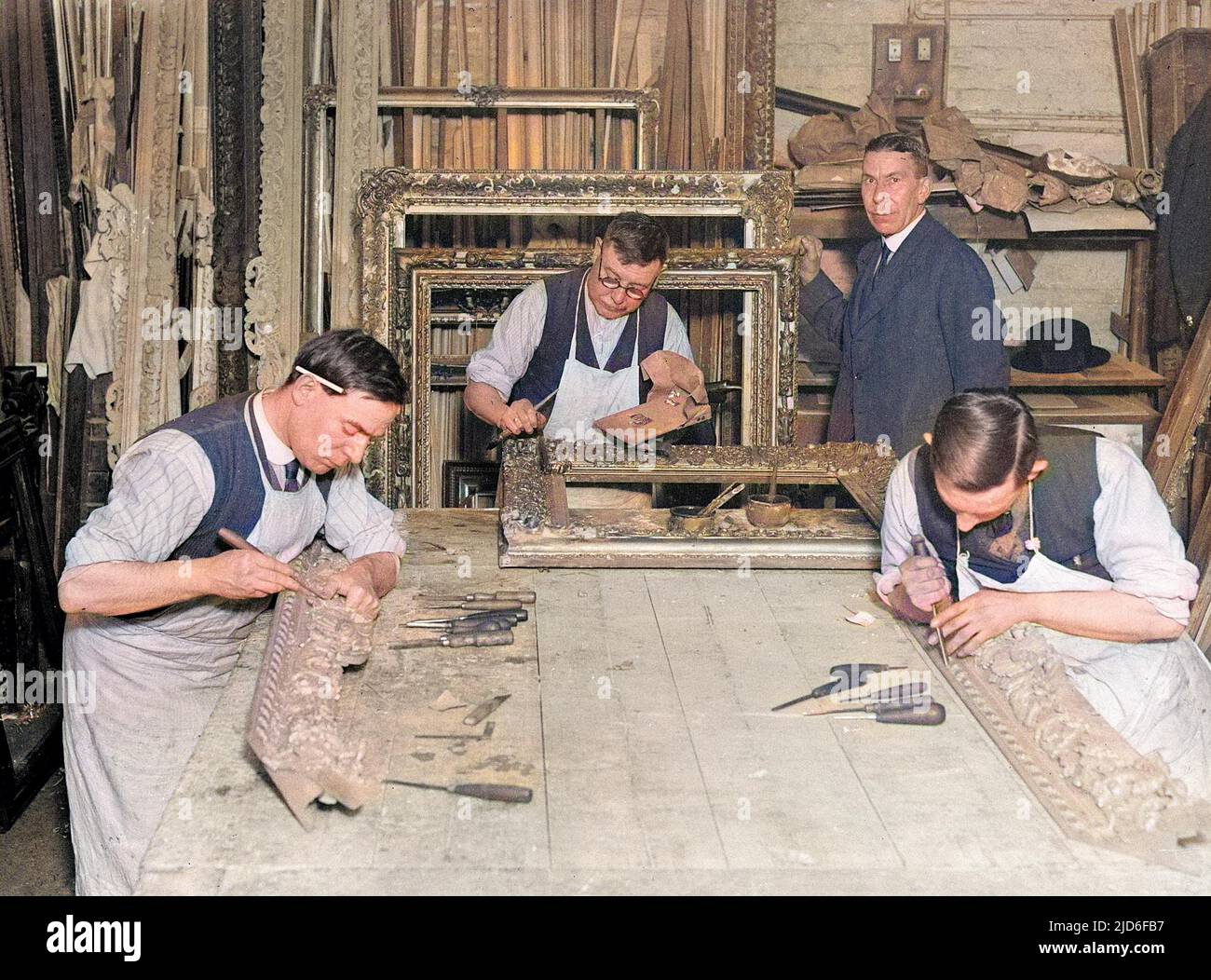 A workshop of busy picture framers, with the foreman or manager ...