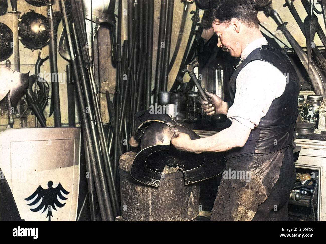 Mr. Rex, 'the last armourer', hammering a helmet into shape. Colourised ...