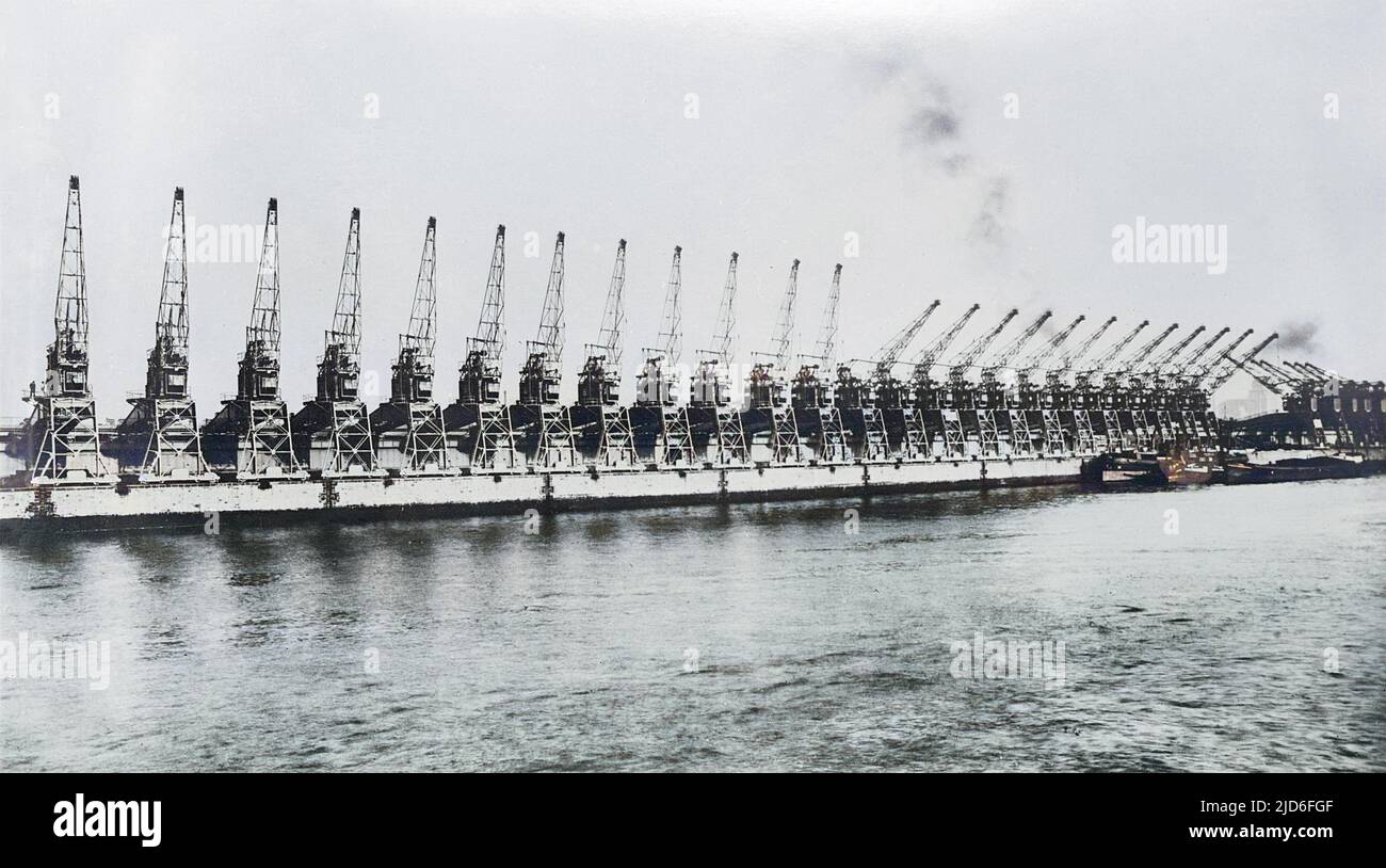A symmetrical row of huge industrial cranes in Germany. Colourised ...