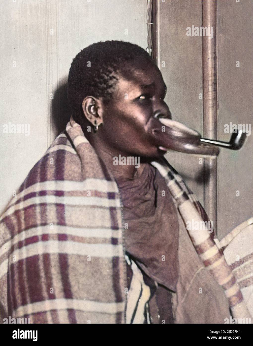 A Congo West African with lip plates (pelele), smoking a pipe ...