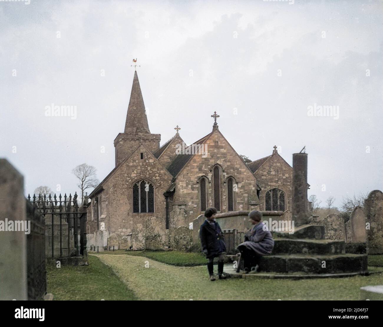 Children sitting outside the tranquil Brading Church, Isle of Wight ...