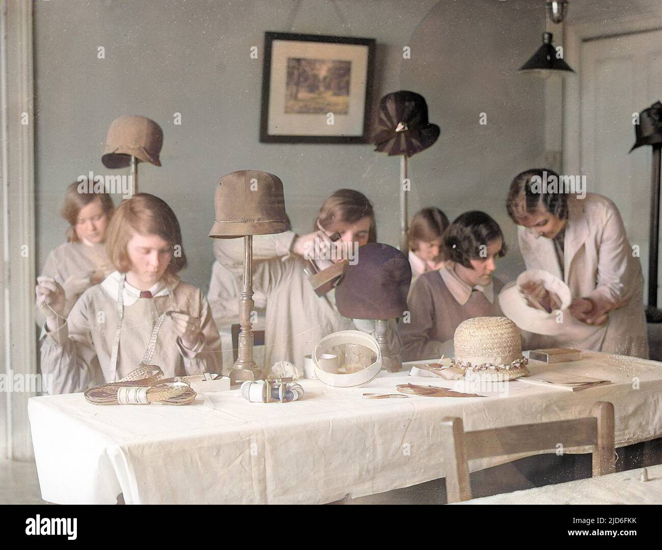 Schoolgirls at a London County Council School learning hat- making in a ...