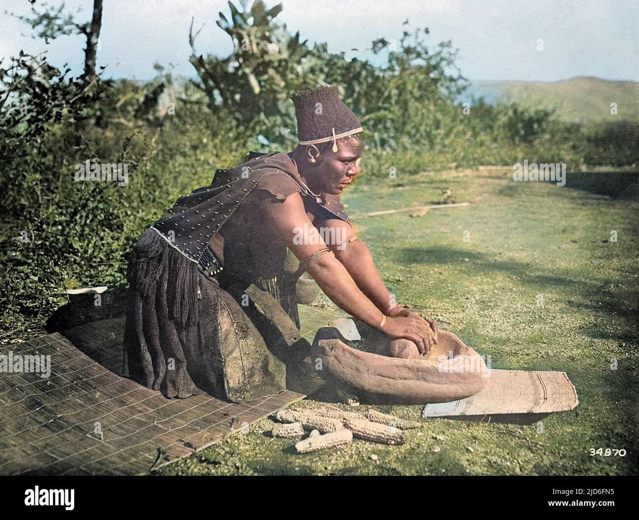 A woman in West Africa, making bread on the banks of a river ...