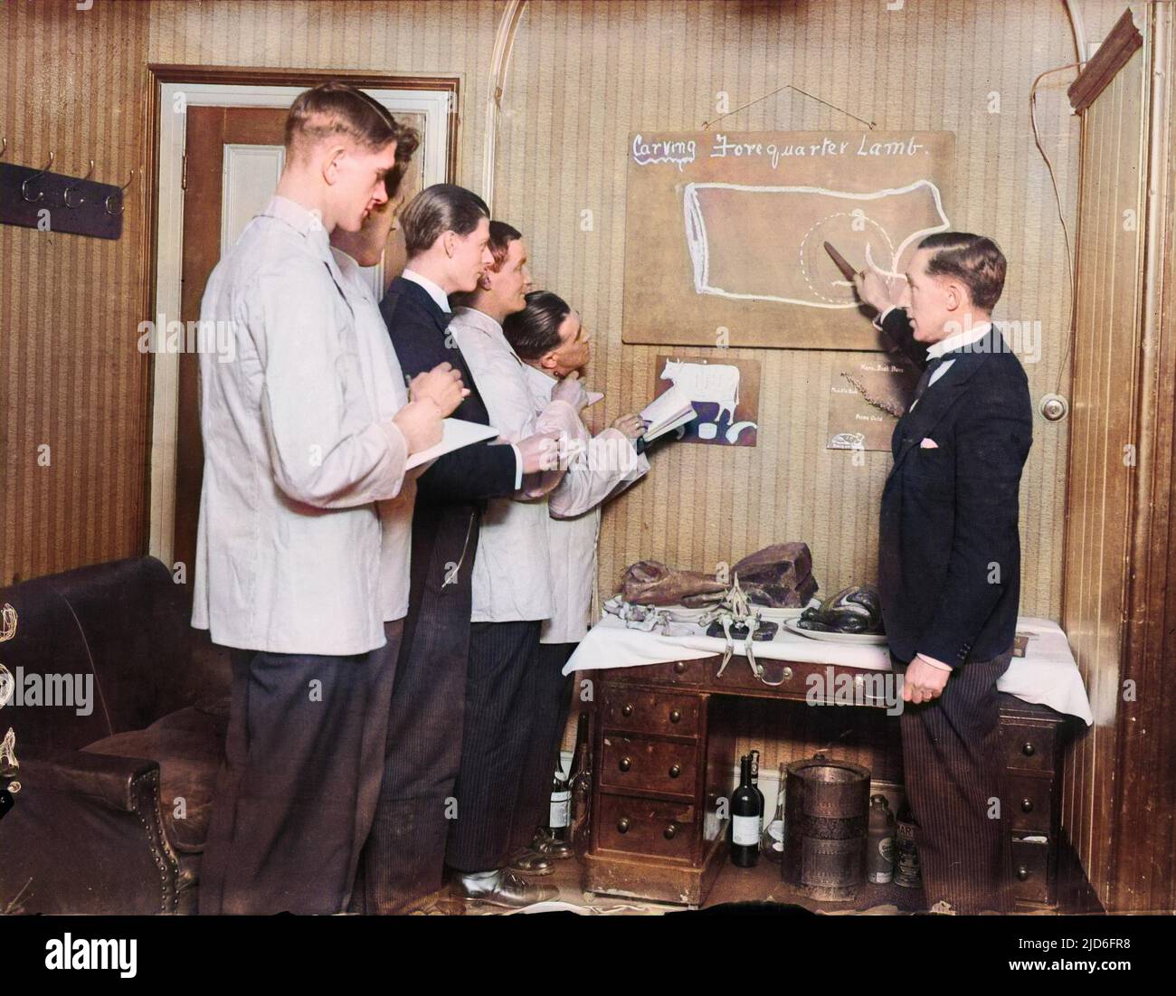Trainee butlers take notes as their teacher points to a blackboard ...