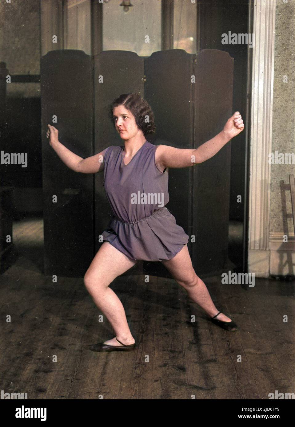 A young woman demonstrates how to perform 'physical jerks' as part of ...