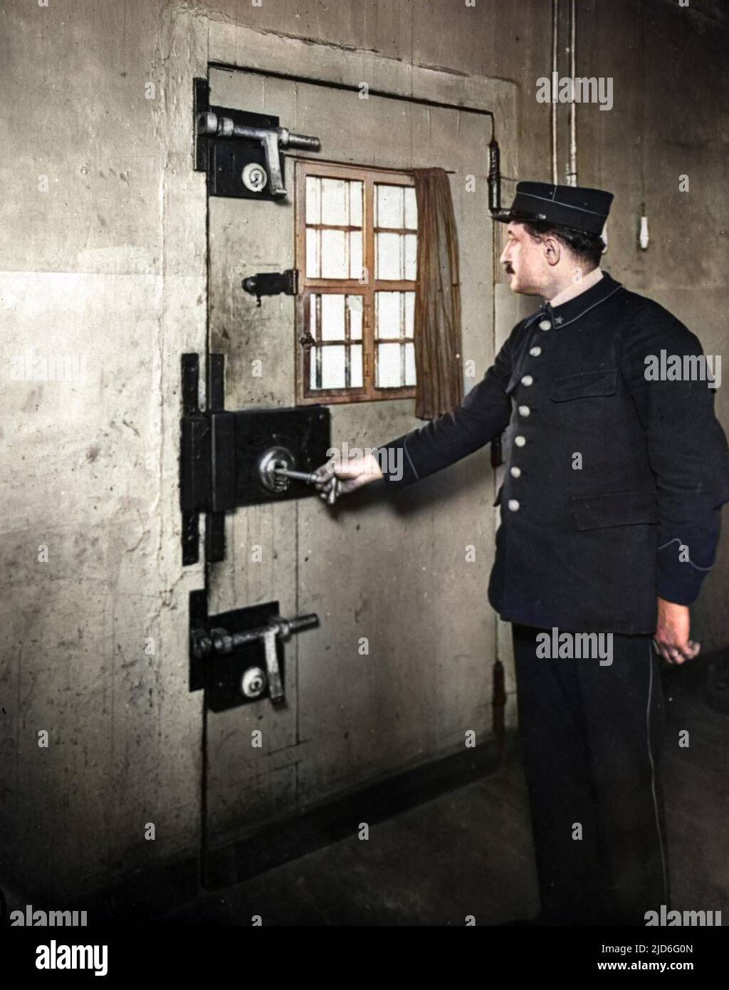A prison guard in a French prison ensures that a cell is safely under ...